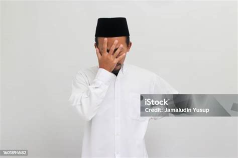 부끄러워하는 젊은 인도네시아 남자가 하얀 배경에 고립된 손으로 얼굴을 가리고 있다 이슬람교에 대한 스톡 사진 및 기타 이미지 이슬람교 죄책감 후회 Istock