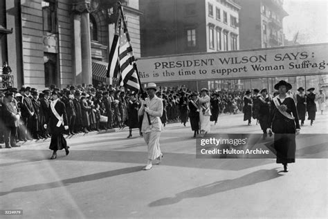 Full Length Image Of Suffragettes Marching With A Banner Declaring