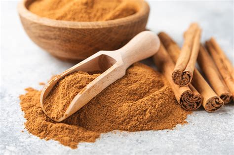 질감이 있는 나무 배경에 계피 가루 베이킹 디저트 및 음료를 위한 매운 향신료 향긋한 계피 가루 시나몬 스틱 텍스트의 위치 공간을 복사합니다 가루 설탕에 대한 스톡 사진 및