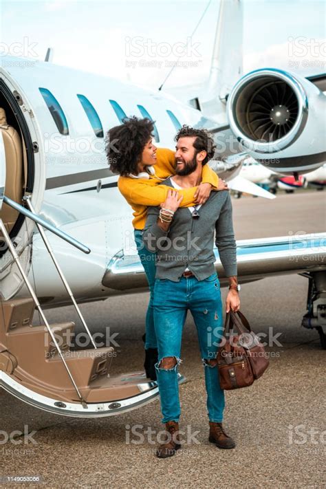 젊은 성공적인 여성은 사랑 스럽게 공항 활주로에 주차 된 개인 비행기 옆 뒤에서 그녀의 파트너를 포용 관광객에 대한 스톡 사진 및 기타 이미지 Istock