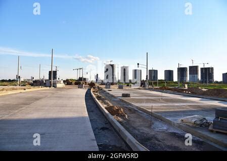 Concrete curbs installation works at road construction site. String ...