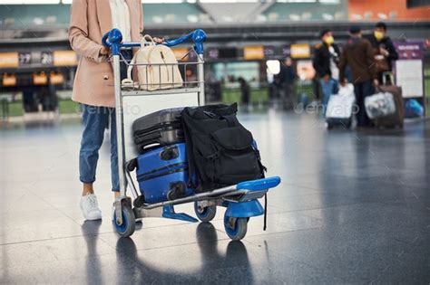 Stylish Young Woman Pushing Luggage Trolley At Airport Airport