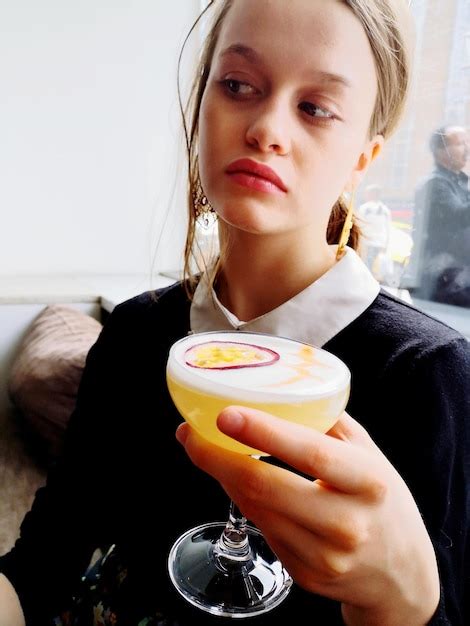 Premium Photo Thoughtful Teenage Girl Holding Drink In Restaurant