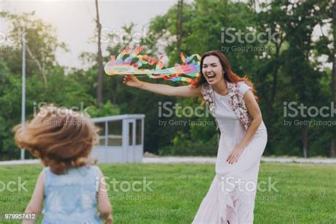 빛 드레스에 귀여운 어린이 아기 여자 놀이 녹색 공원에서 잔디에 화려한 연 웃는 여자 어머니 딸 아이입니다 어머니의 날 사랑 가족 부모 어린 시절 컨셉 2명에 대한 스톡