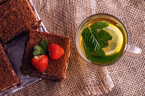 테이블 위의 삼베에 차 레몬 한 잔과 박하 잎이있는 달콤한 딸기 파이 조각 0명에 대한 스톡 사진 및 기타 이미지 0명