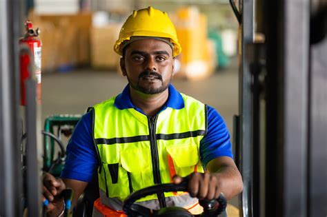 창고 공장에서 지게차를 운전하는 인도 남자 노동자 재고 및 도매 개념 팔레트와 상자를 컨테이너로 이동 25 29세에 대한 스톡