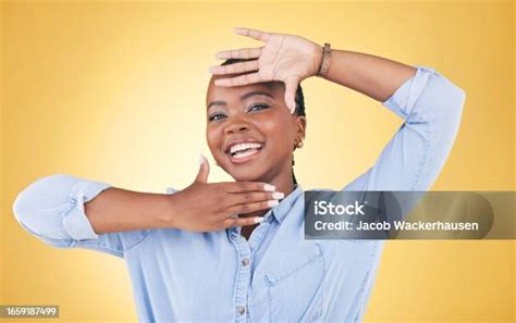 자신감 창의성 아름다움을 위해 스튜디오에서 행복한 흑인 여성의 손 프레임 및 초상화 사진 관점 및 화장품 메이크업 또는 글래머의 노란색 배경에 있는 아프리카 사람의 얼굴