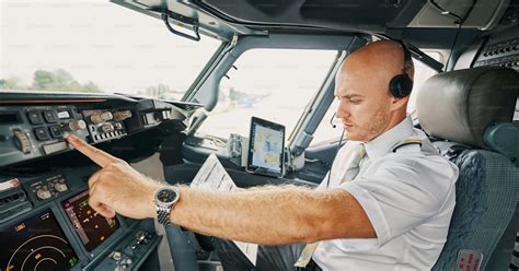 조종석에 혼자 앉아 비행 전 체크리스트를 손에 든 진지한 남성 조종사 사진 Unsplash의 앉아 이미지