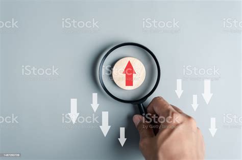 돋보기를 들고 있는 손은 빨간색 화살표에 초점을 맞추고 다른 방향은 비즈니스 중단 및 기술 혁신 및 다른 사고 아이디어 개념을 위해 흰색 화살표와 반대 방향을 향하고