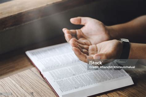 기독교 남자는 성경과 하나님께기도 손 선함을 믿으십시오 더 나은 삶을 소망하시는 하나님의 축복을 위해 나무 식탁에 손을 들고 기도하고 예배 개념 개념에 대한 스톡 사진 및