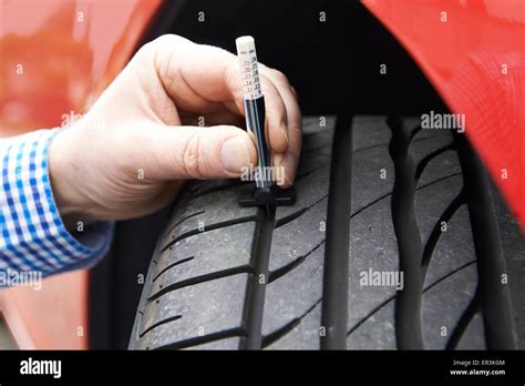 Close Up Of Man Checking Tread On Car Tyre With Gauge Stock Photo Alamy