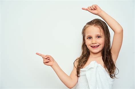 빈 공간을 향해 손가락으로 가리키는 흰 수건에 싸여 흰색 배경에 대해 촬영 젖은 머리를 가진 작은 유치원 소녀를 웃 고 가리기에 대한 스톡 사진 및 기타 이미지 Istock