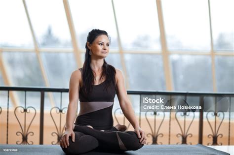 운동 요가 연습을 하 고 Ardha Padmasana 로터스 편안한 포즈에에서 앉아 아름 다운 젊은 여자 전체 길이 큰 창 배경 Pranayama에 대한 스톡 사진 및 기타