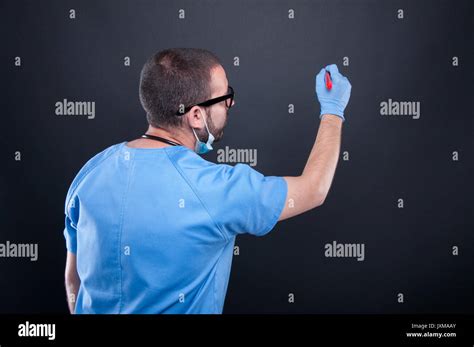 Back View Medic Wearing Glasses Writing On Invisible Board With Red