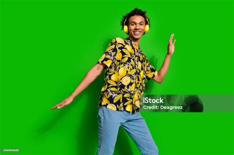 쾌활 한 낙천적 인 남자가 세련된 여름 인쇄 복장을 입고 녹색 배경에 고립 된 음악을 듣는 것을 즐긴다 사진 20 24세에 대한 스톡 사진 및 기타 이미지 Istock