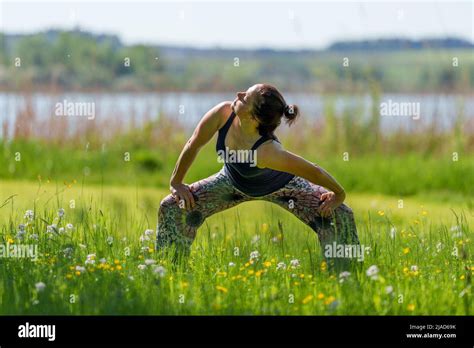 Woman Doing Standing Cat Cow Yoga Pose By Wallersee Salzburg Austria