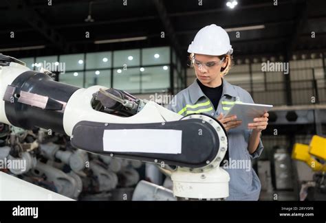 A Female Engineer Installs A Program On A Robotics Arm In A Robot