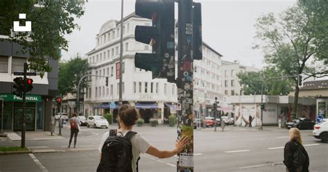 도시 거리의 신호등 옆에 서 있는 남자 사진 Unsplash의 무료 보 훔 이미지