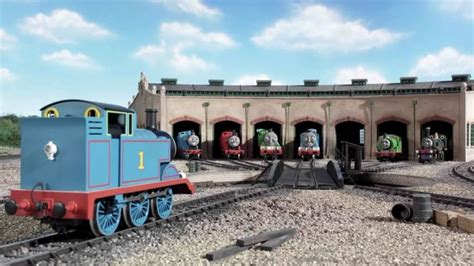 There Is A Train That Is On The Tracks In Front Of A Building With Arches