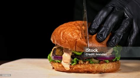 컷 크래프트 버거는 검은 배경에 요리 소스 살사 양상추 붉은 양파 피클 치즈 칠리 피망 롤빵 대리석 고기 쇠고기로 구성됩니다 검은색에 대한 스톡 사진 및 기타 이미지