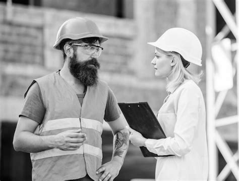 Premium Photo Woman Engineer And Bearded Brutal Builder Discuss Construction Progress