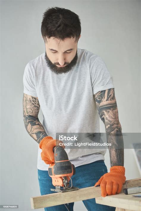 잘생긴 나무 판자를 들고와 전기 직소를 사용 하 여 문신된 남자 수염 가정의 방에 대한 스톡 사진 및 기타 이미지 가정의 방 개선 남자 Istock
