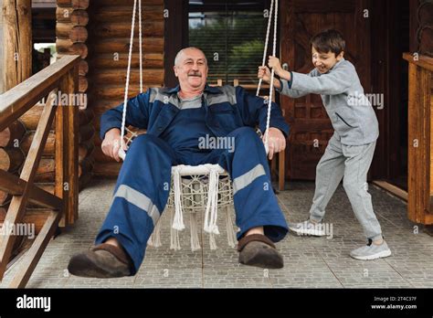 Grandson Shakes Grandpa On Swing Stock Photo Alamy
