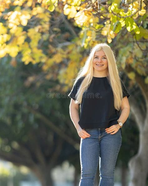 Woman With Braces Standing In Front Of Tree With Hands On Hips Stock Image Image Of Friendly