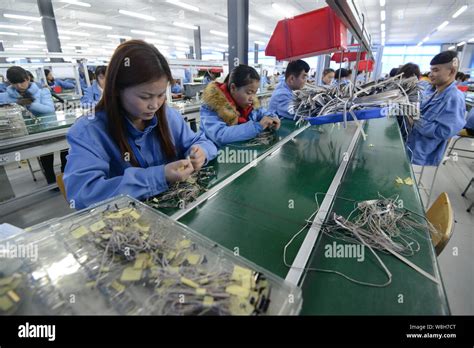 Female Chinese Workers Produce Electronic Accessories On The Assembly