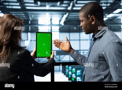 System Administrators In Data Center Use Green Screen Tablet To Calibrate Energy Usage