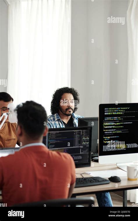 Indian Software Engineers Working On Computers In Open Space Office