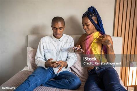 아프리카 계 미국인 비 바이너리 사람과 트랜스 젠더 여성은 스마트 폰과 대화를 사용하여 침대에서 성소수자 부부 2명에 대한 스톡 사진 및 기타 이미지 Istock