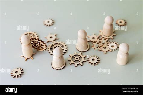 A Conceptual Image With Wooden Figures Standing On Interconnected Gears Teamwork Collaboration