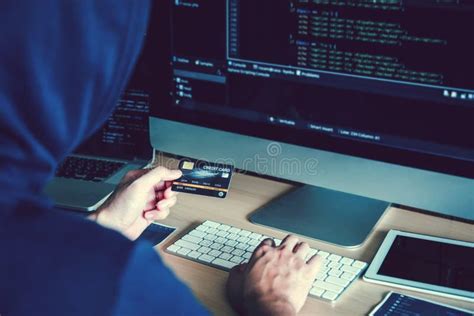 Dangerous Hooded Hacker Using Credit Card Typing Bad Data Into Computer Online System And
