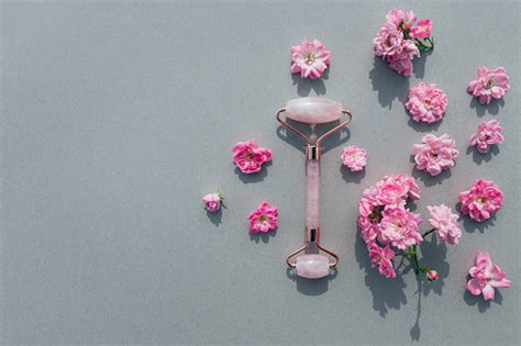 홈 스파를위한 얼굴 마사지 도구 장미 새싹이있는 회색 파스텔 배경에 장미 석영으로 만든 얼굴 롤러 자연 치료 개념 상단 보기 플랫 레이 괄사에 대한 스톡 사진 및 기타