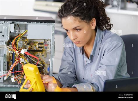 Woman Checking Computer With A Multimeter Stock Photo Alamy