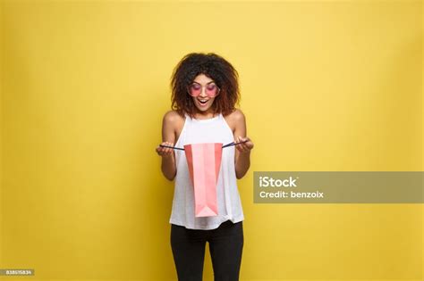 쇼핑 개념세로 젊은 아름 다운 매력적인 아프리카 여자 다채로운 쇼핑 가방 놀라운 닫습니다 옐로우 파스텔 벽 배경입니다 공간에 복사 합니다 가방에 대한 스톡 사진 및 기타