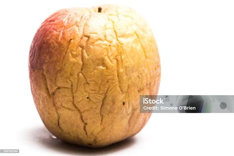 Shriveled Yellow And Red Apple With Deep Wrinkles On White Background