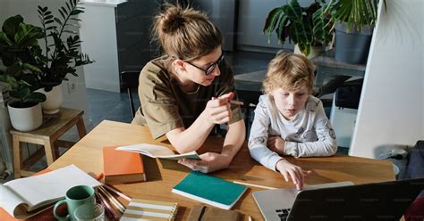 노트북을 사용하고 집에서 테이블에 앉아 있는 동안 튜터와 함께 온라인 작업을 하는 어린 소년 사진 Unsplash의 테이블 이미지