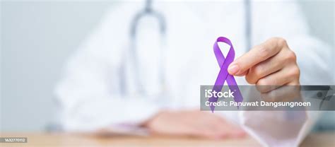 폭력 췌장암 식도암 고환암 알츠하이머 간질 루푸스 유육종증 및 섬유 근육통에 대한 보라색 리본을 들고있는 의사 인식의 달과 세계 암의 날 개념 리본에 대한 스톡 사진 및