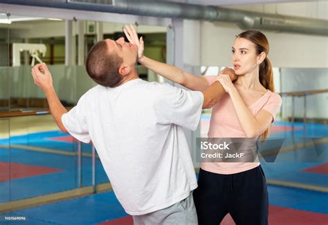 Young Woman Practicing Palm Strike With Man In Self Defense Training