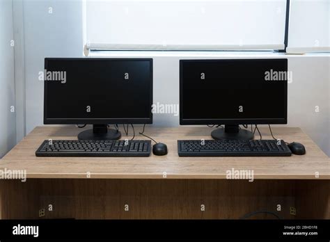 Two Computers And A Desk Keyboard And Mouse Two Computer Monitors With A Black Screen On A
