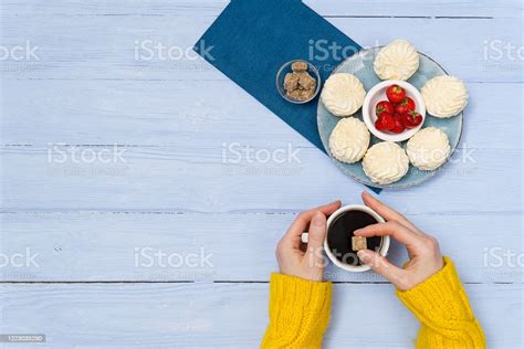 복사 공간이있는 오래된 나무 테이블 상단보기에 손에 커피 머그잔 커피 한 잔을 들고 아늑한 노란색 홈 스웨터에 여자와 설탕을