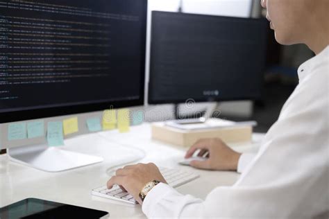 Programmer Working Is On Computers With Multiple Monitors Back View