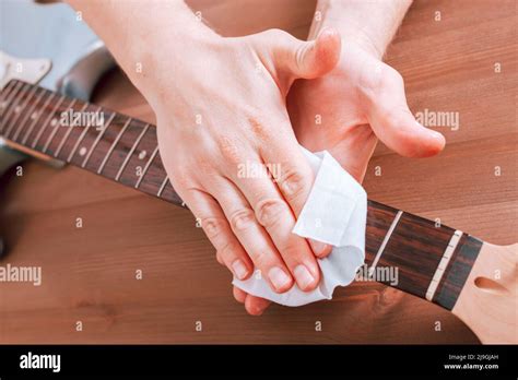Guitar Master Polishing Fretboard Of Electric Guitar Close Up Shot Of Hands With Cloth Stock