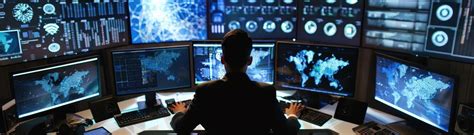 Person Monitoring Multiple Screens With World Maps And Data Charts In A Control Room Environment