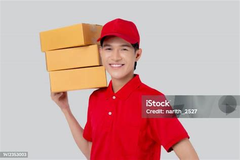 유니폼 빨간색과 모자를 쓴 젊은 아시아 남자는 상자 스택을 격리 된 흰색 배경 직원화물 또는 패키지 택배 및 배달 운송 및 서비스 물류 및화물을 들고 있습니다 나름에 대한