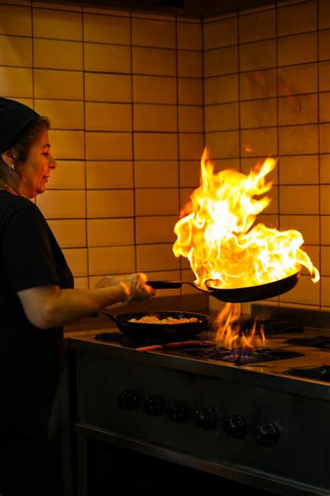 불 불꽃 셰프 수직 쐈어 여성 요리하다 음식 준비하기 잡고 있는 주방 프라이팬에 관한 무료 스톡 사진