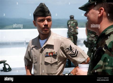 A Navy Corpsman In A Marine Corps Uniform Talks With Another Serviceman