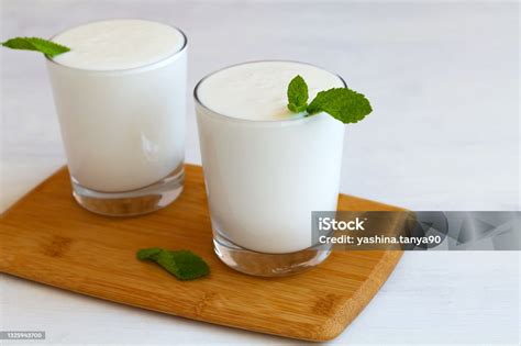 나무 테이블에 녹색 민트 요구르트 두 잔 클로즈업 신선한 유제품 음료건강 발효 제품 개념 공간을 복사합니다 케피르 우유 또는 라시 음료와 프로바이오틱스를 테이블에